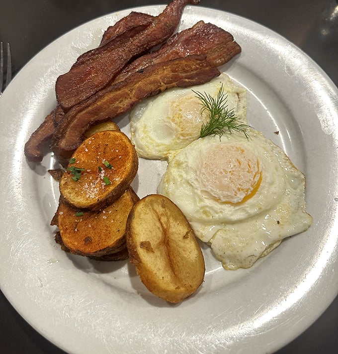 The breakfast trinity – crispy bacon, golden eggs, and home fries that actually taste like potatoes instead of sad afterthoughts. This is how mornings were meant to begin.