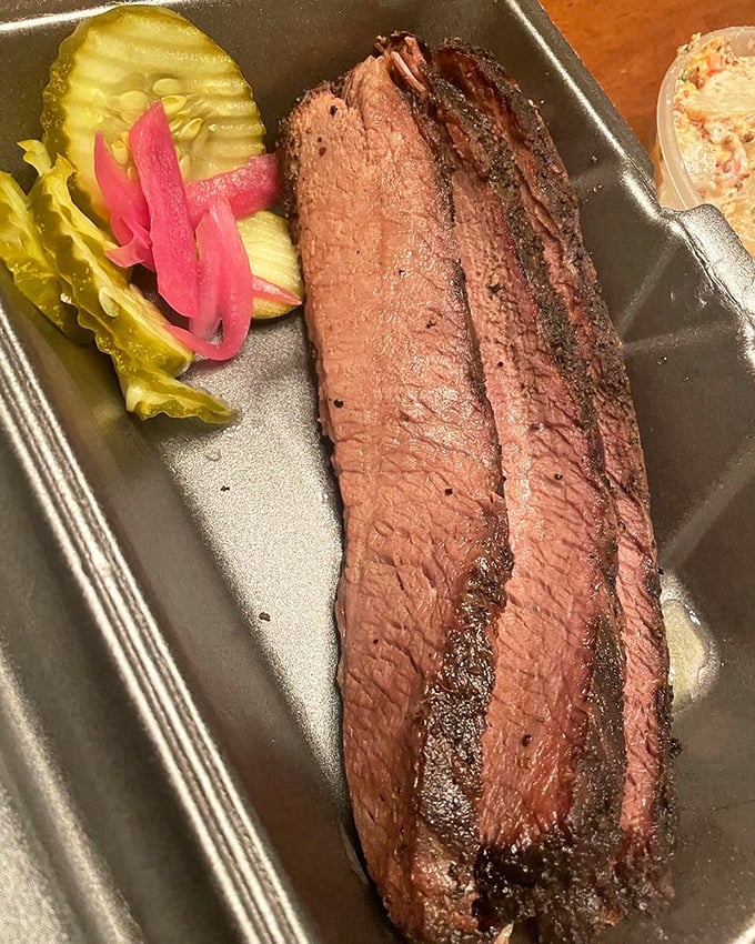 Brisket so perfectly pink-ringed it deserves its own museum exhibit. The pickle and onion garnish adds that perfect acidic counterpoint to smoky richness.