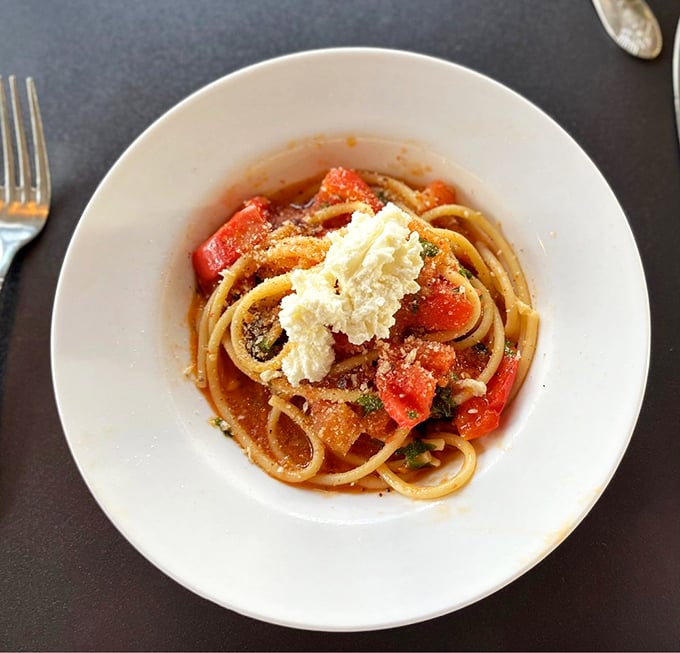 The bucatini that launched a thousand road trips—perfectly al dente pasta with fresh tomatoes and a crown of ricotta that melts into saucy perfection.
