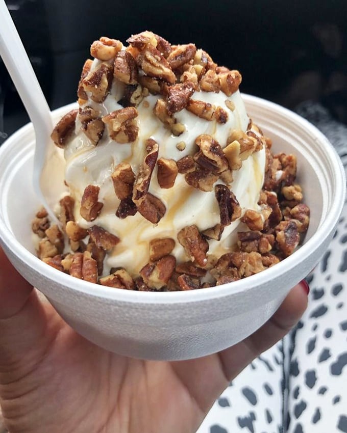 The butter pecan sundae arrives like edible architecture—vanilla soft serve draped in caramel and crowned with a generous landslide of candied pecans. Diet plans surrender immediately.