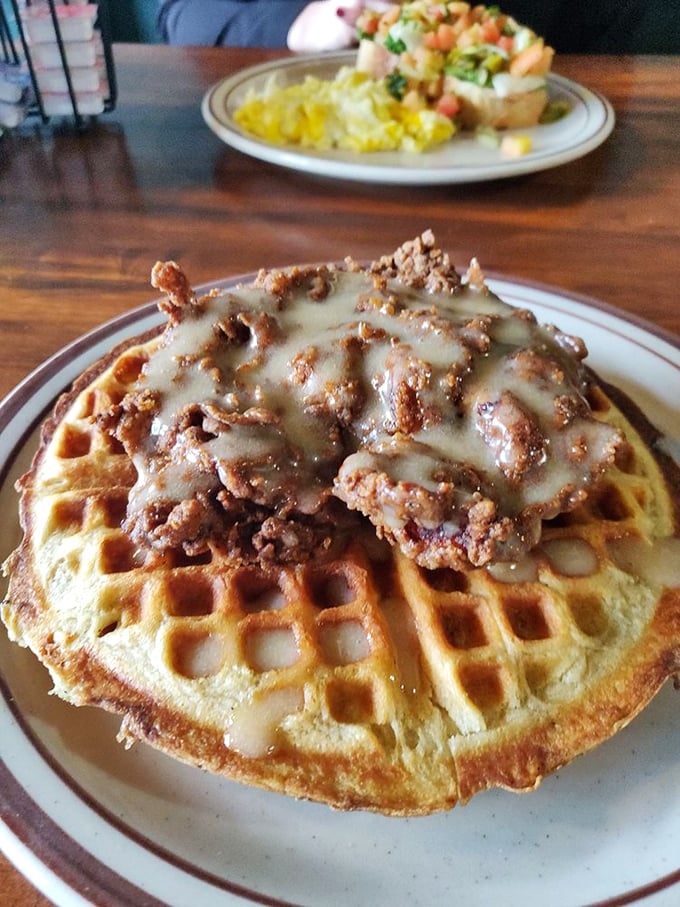 Behold the crown jewel: golden-brown chicken perched atop a perfect waffle, drizzled with maple cream sauce—a sweet-savory masterpiece that's worth every mile driven.