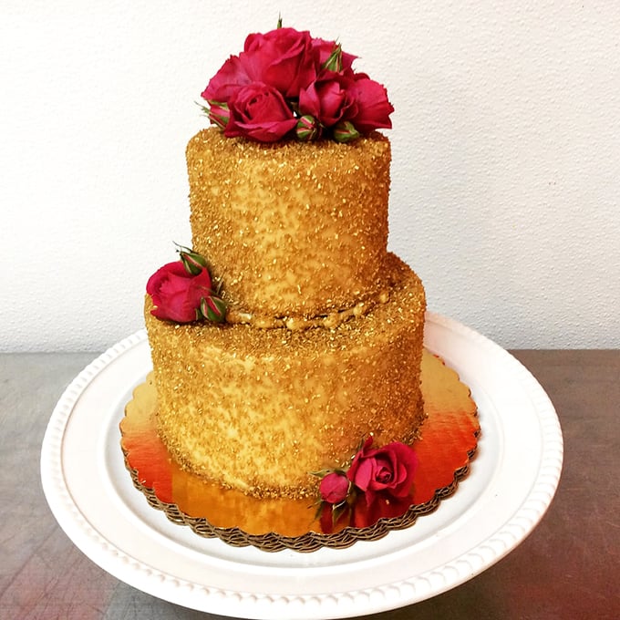 Gold-dusted elegance crowned with fresh roses. This isn't just cake—it's what Marie Antoinette would have actually meant by "let them eat cake."