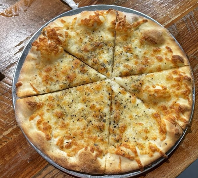 This white pizza isn't just a meal—it's a religious experience with perfectly blistered crust and herbs that mean business. 