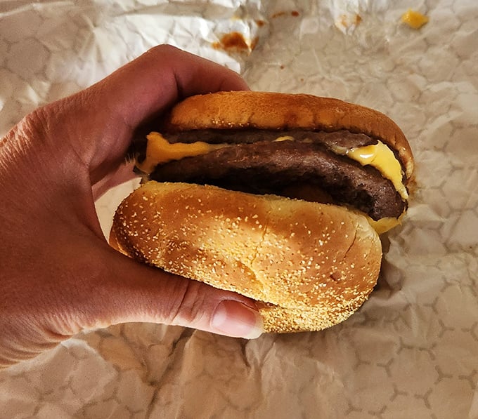 This isn't just a cheeseburger—it's edible architecture, where beef and melted American cheese create a symphony of savory perfection between two golden buns.