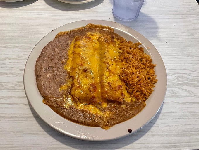 Behold, the holy trinity of Tex-Mex perfection: cheese enchiladas, refried beans, and Spanish rice. A plate that's worth every calorie and food coma that follows.
