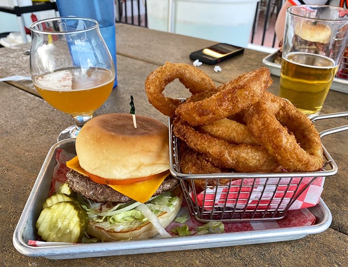 Burger perfection doesn't need fancy frills. Just look at that melty cheese, fresh toppings, and those golden onion rings standing at attention.