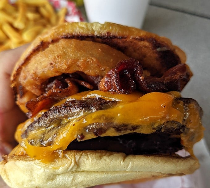 This isn't just a cheeseburger—it's edible architecture. The melted cheese cascading over the patty like a yellow waterfall of happiness.