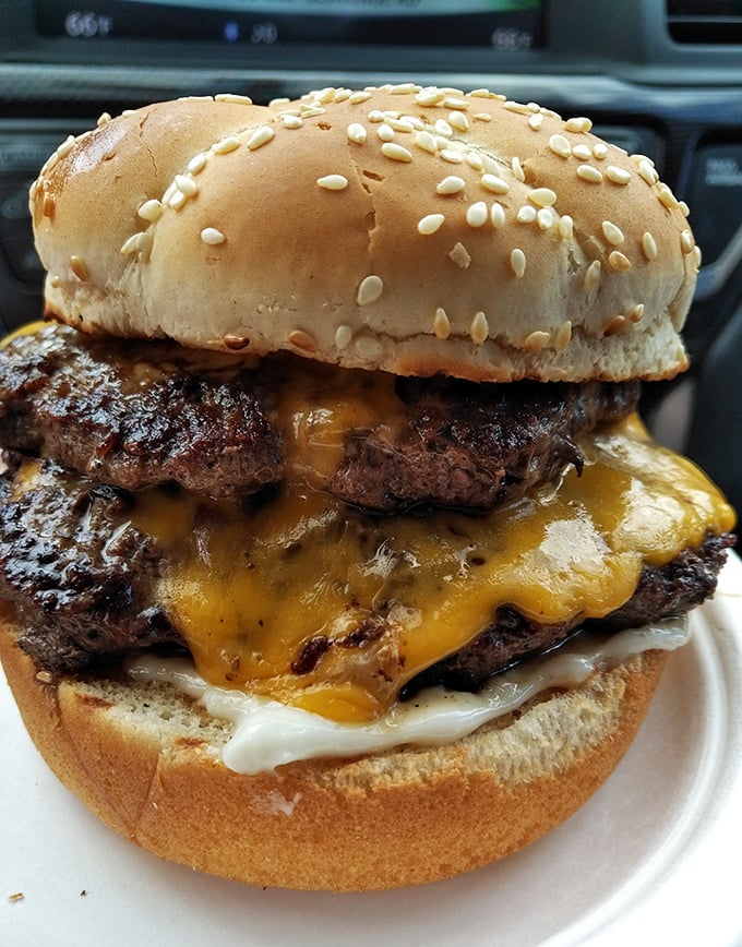 Behold the Double Bunny Burger in its natural habitat—a masterpiece of melted cheese cascading over beef patties like Niagara Falls, but tastier.