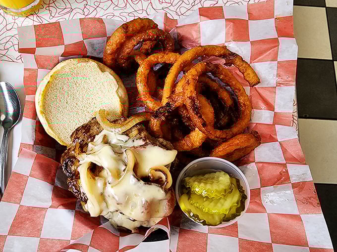 Behold the burger that launched a thousand food dreams—melty cheese cascading over a juicy patty, with golden onion rings standing guard like delicious sentinels.