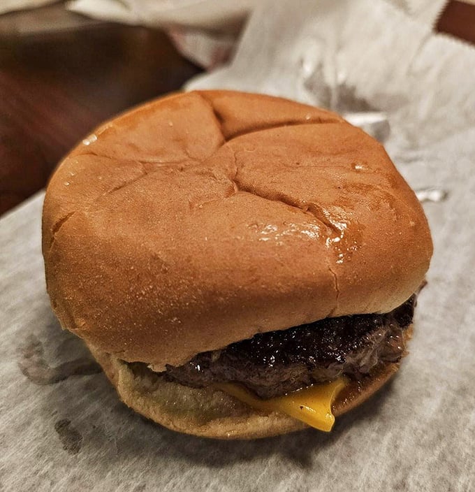 Behold the star of the show – a perfectly grilled burger with melted cheese on a soft bun. No Instagram filters needed for this beauty.