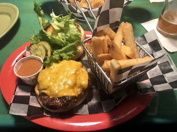Behold the classic cheeseburger in its natural habitat—perfectly melted cheese cascading down a hand-formed patty, with crispy fries standing at attention nearby.