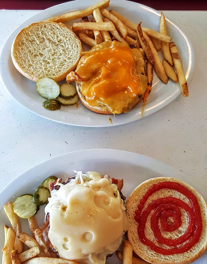 Behold the cheeseburger in its natural habitat—surrounded by golden fries and pickle spears. A masterpiece of American cuisine.