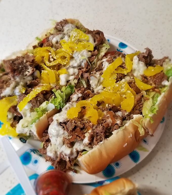 Behold the famous Pounder Cheesesteak in all its glory—where thinly sliced beef, melted cheese, and banana peppers create a holy trinity of flavor.