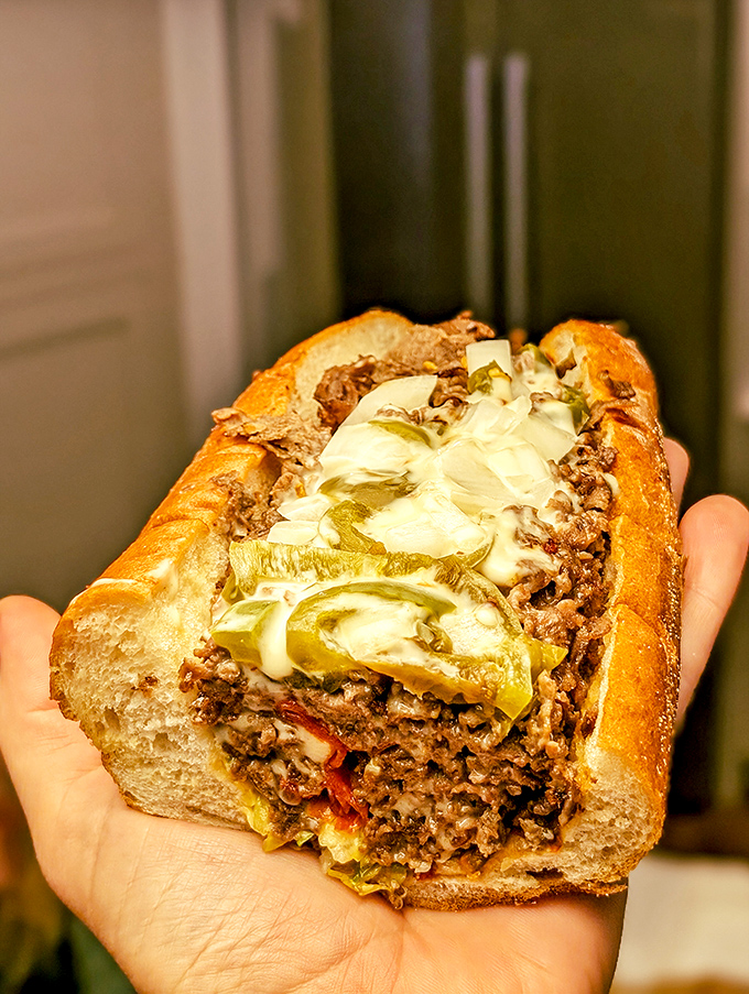 Behold the architectural marvel that is a proper cheesesteak – cheese cascading like delicious lava over perfectly seasoned beef.