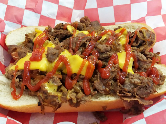 Behold the cheesesteak in its natural habitat! Tender meat, melty cheese, and that splash of ketchup creating the holy trinity of sandwich perfection.