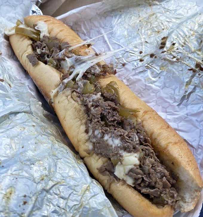 Behold the star of the show—thinly sliced beef, melted cheese, and peppers cradled in a perfect roll. This isn't just lunch; it's edible architecture.