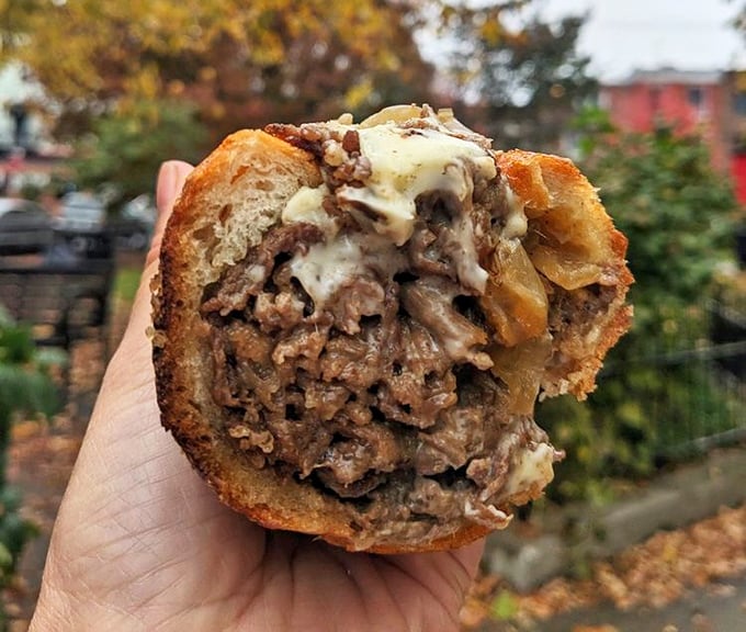 Behold the star of the show—a cheesesteak so perfectly constructed it should have its own Philadelphia mural. Just look at that cheese pull!