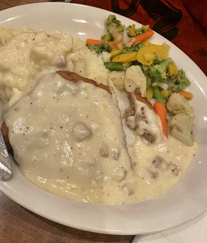 Country-fried steak swimming in creamy gravy – where the crispy exterior gives way to tender meat beneath, like finding an oasis in the desert.