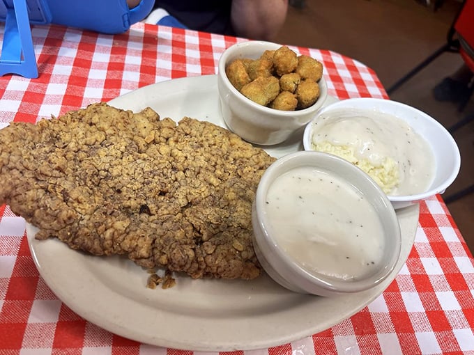 Behold the chicken fried steak in its natural habitat - golden, crispy, and large enough to make your cardiologist wince from miles away.