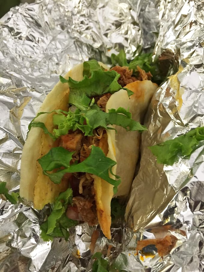 Behold the star of our show: a chicken taco cradled in foil like the culinary treasure it is. That fresh cilantro isn't just garnish—it's a promise.