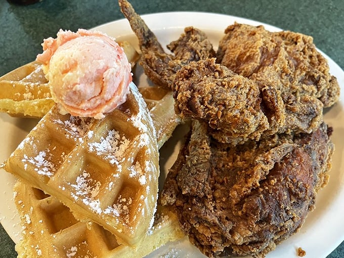 Behold the crown jewel: golden-fried chicken atop a Belgian waffle with strawberry butter. This isn't just breakfast—it's performance art.