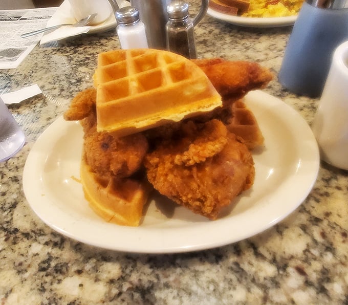 Behold the star attraction! Golden waffles cradle perfectly fried chicken in a relationship that proves opposites really do attract deliciously.
