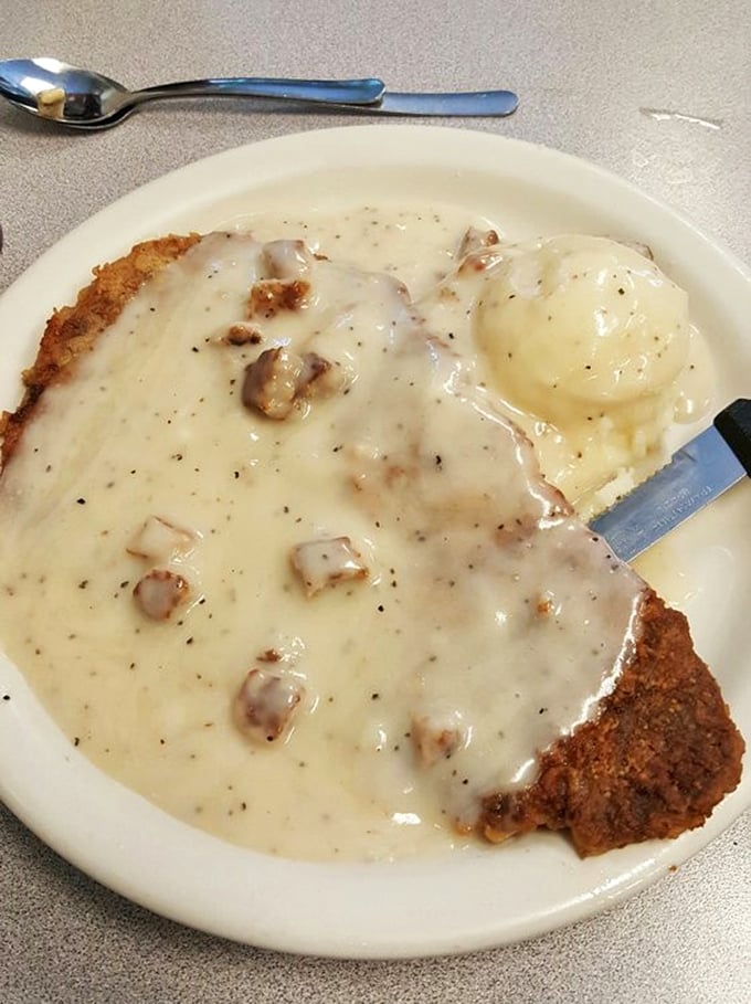 Behold the legendary chicken fried steak—a golden-crusted masterpiece swimming in peppery gravy that would make your grandmother weep with joy.