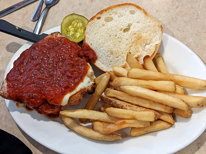 Not all heroes wear capes – some come smothered in marinara and melted cheese, served alongside golden fries and a pickle spear for moral support.