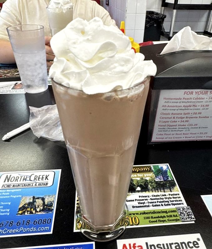 This isn't just a milkshake—it's a skyscraper of dairy delight topped with a cloud of whipped cream that demands respect.