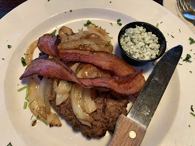 A perfectly seasoned steak topped with caramelized onions and bacon. The blue cheese side cup isn't optional—it's essential bliss.