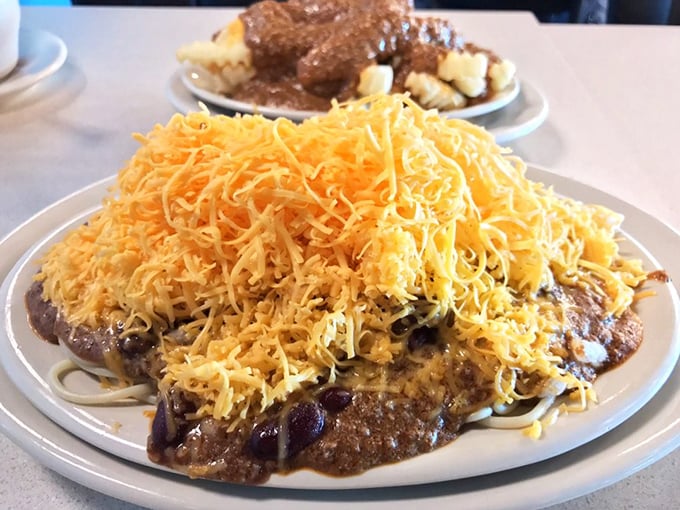 Behold the legendary Cincinnati five-way: a mountain of finely shredded cheddar atop spiced chili, spaghetti, beans, and onions—architecture you can eat.