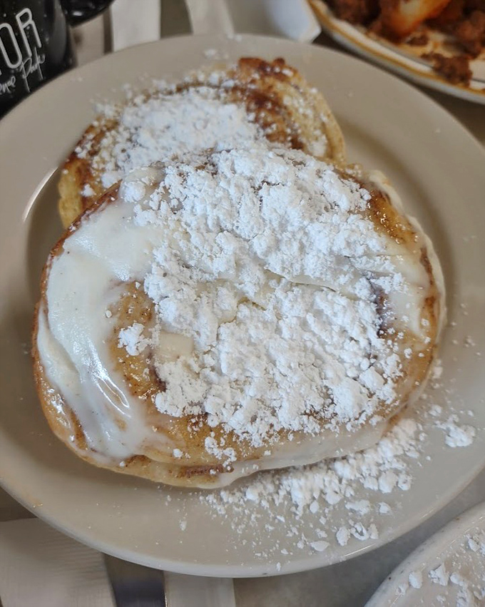 That's not just a cinnamon roll—it's a powdered sugar mountain with a warm, gooey center waiting to change your life.