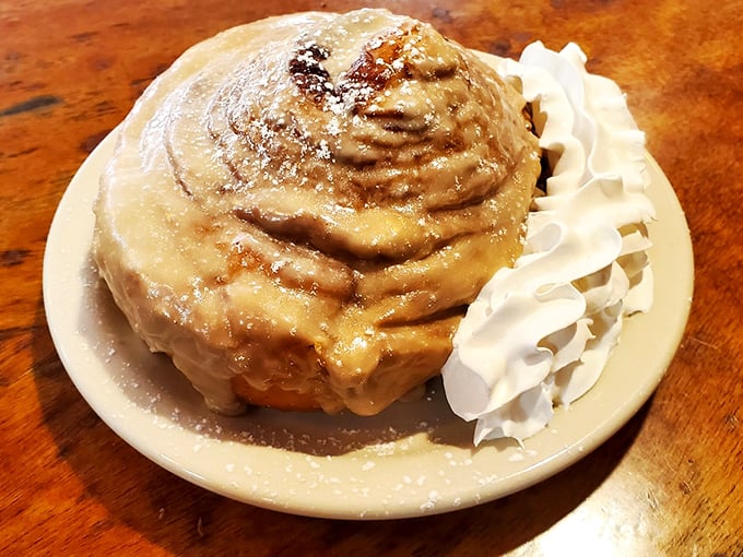 Behold the crown jewel – a cinnamon roll so magnificent it deserves its own zip code, complete with cream cheese icing waterfall.