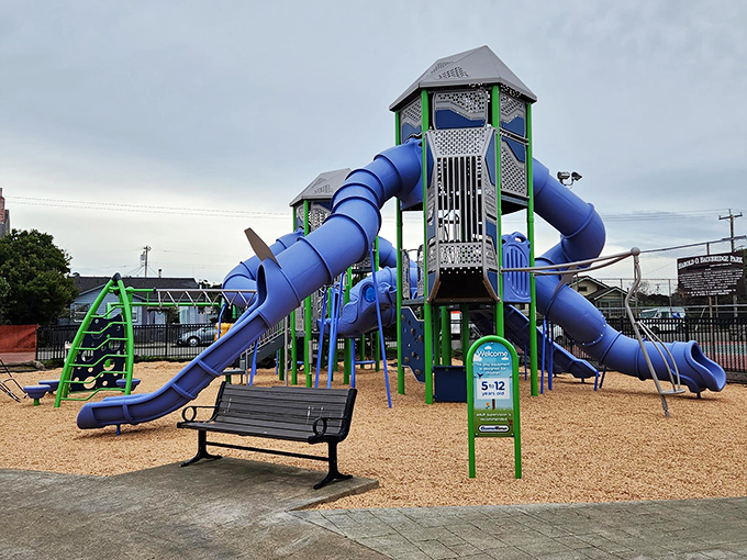 Kids climbing on blue slides while parents enjoy a moment of peace—Fort Bragg's playgrounds offer family fun without the theme park prices.