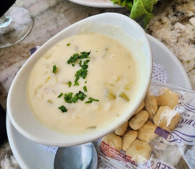 Creamy clam chowder that makes you question all other chowders in your life—sprinkled with fresh herbs and accompanied by oyster crackers for essential dipping.