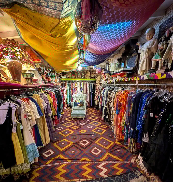 Down the rabbit hole you go—fabric-draped ceilings and geometric carpets create a bohemian bazaar where vintage clothing becomes art.