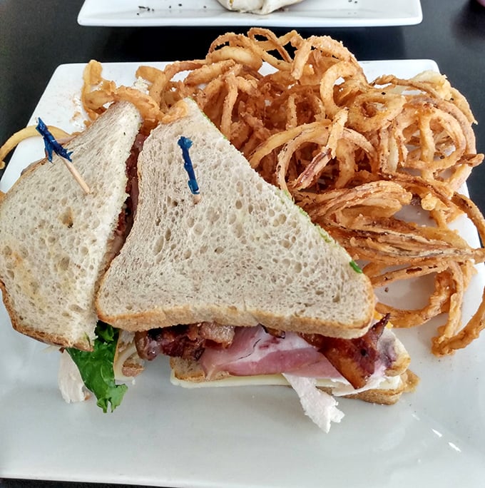 
The legendary club sandwich in all its glory—perfectly stacked layers of meat and veggies held together by toasted bread and blue toothpicks of ambition. 