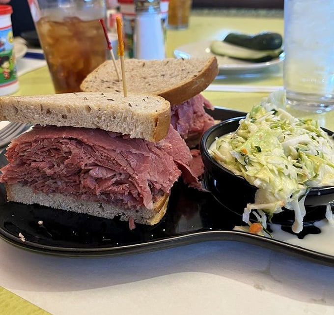 Behold the star attraction – layers of hand-sliced corned beef stacked higher than your expectations, with coleslaw standing by for the perfect bite balance.
