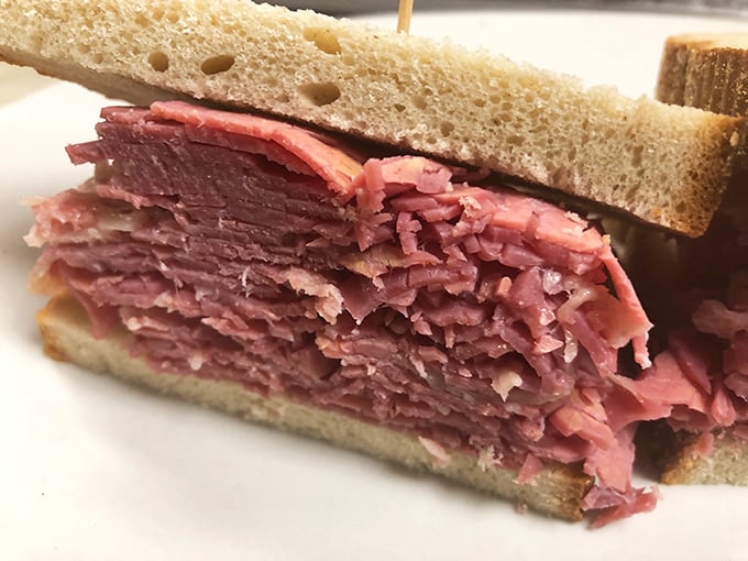 Behold the star attraction—layers of hand-sliced corned beef stacked with such generous abandon between rye bread that you'll need to strategize your first bite.