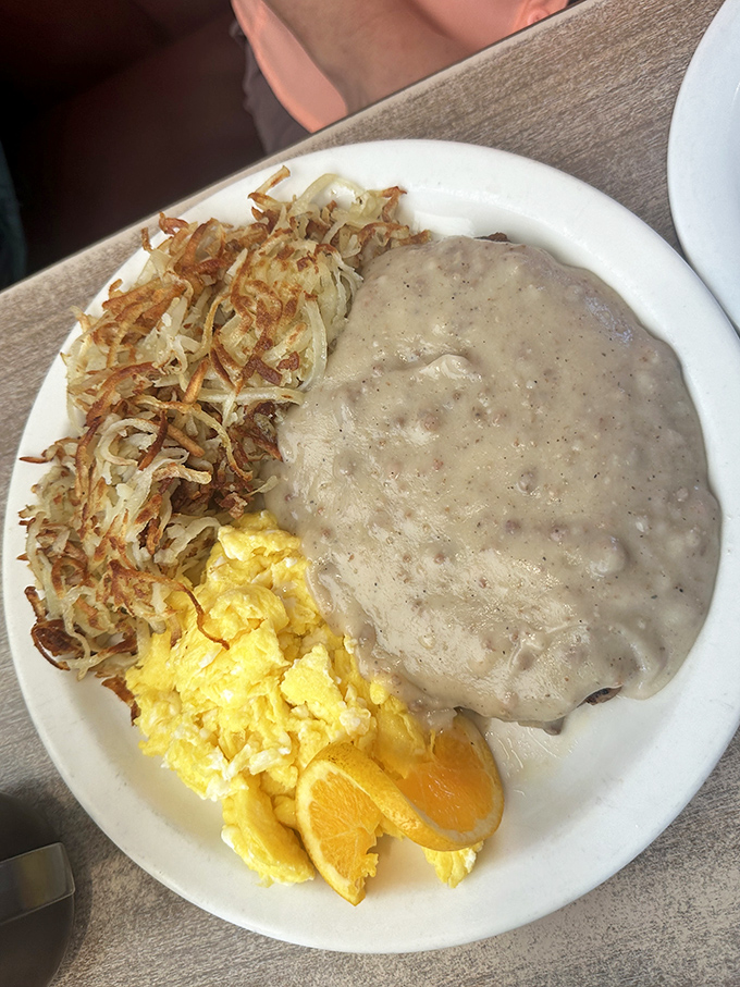 Country fried steak nirvana! Crispy coating, tender meat, and that peppery gravy cascading over everything—with hash browns and eggs playing perfect supporting roles.
