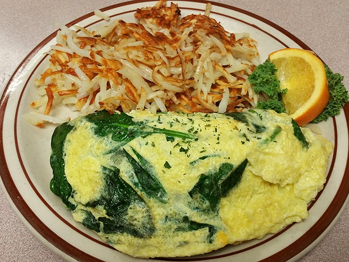 This crab omelet doesn't just flirt with perfection, it's in a committed relationship—golden eggs embrace vibrant greens while hash browns stand crispy guard.