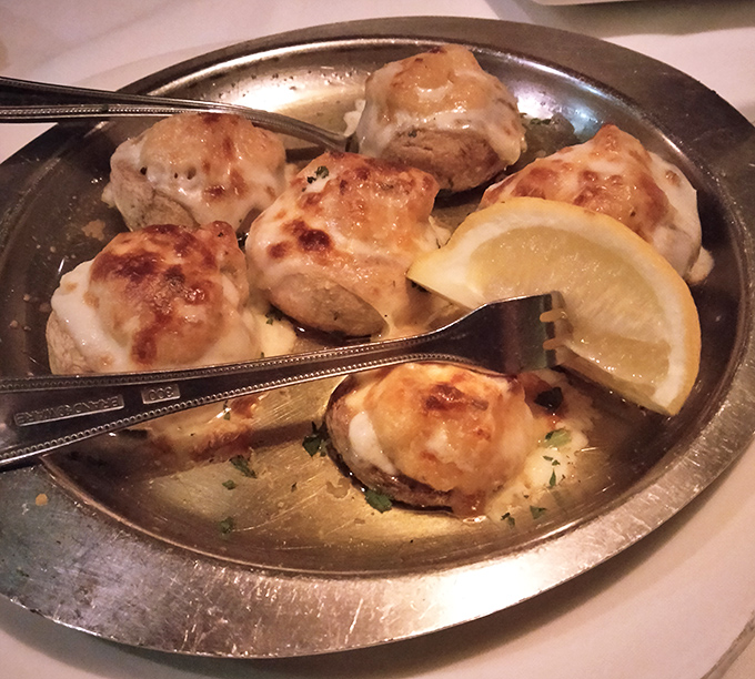 These aren't just mushrooms – they're little boats of happiness sailing on a sea of buttery goodness, carrying precious crab cargo to your taste buds.