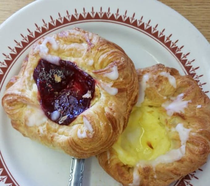 These Danish pastries aren't just breakfast, they're an edible art form – flaky spirals cradling jewel-toned raspberry and sunny custard centers.