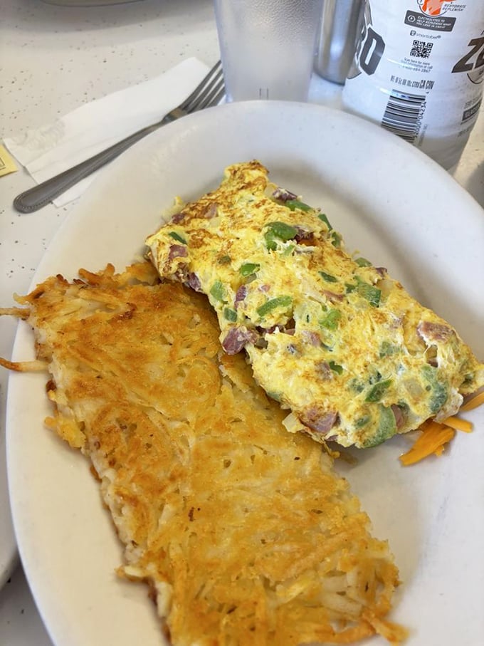 This Denver omelet isn't trying to reinvent breakfast – it's perfecting it. Golden eggs embrace ham and peppers while those hash browns deserve their own fan club.
