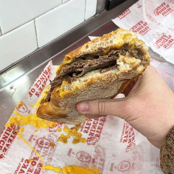 Behold the cross-section of perfection—ribbons of beef embraced by melted cheese in a crusty-yet-soft roll sanctuary.