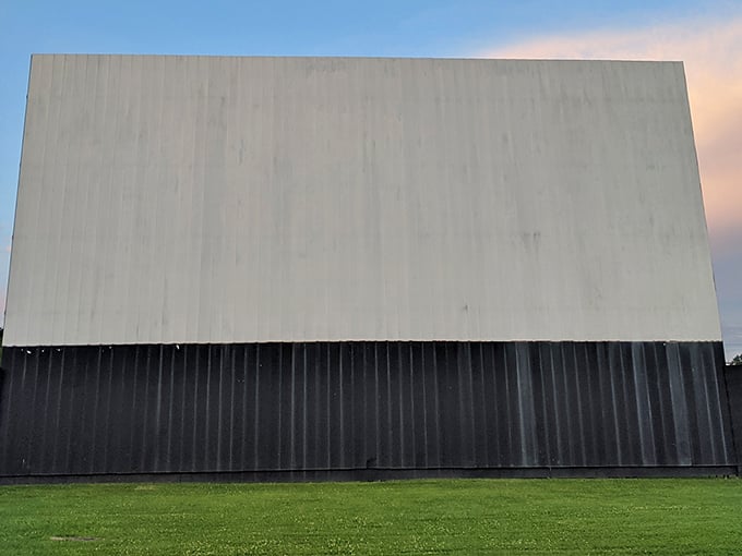 Up close with the towering drive-in screen – where Hollywood blockbusters come to life against darkening Ohio skies.