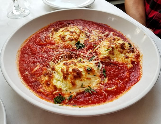 Behold the legendary eggplant parmesan—golden, bubbling perfection swimming in a sea of vibrant marinara that would make any Italian grandmother nod in approval. 