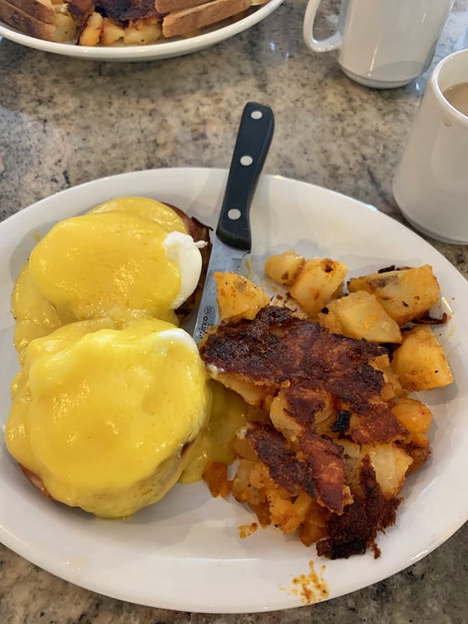 Eggs Benedict that would make a French chef weep with joy – perfectly poached eggs draped in hollandaise with home fries crisped to golden perfection.