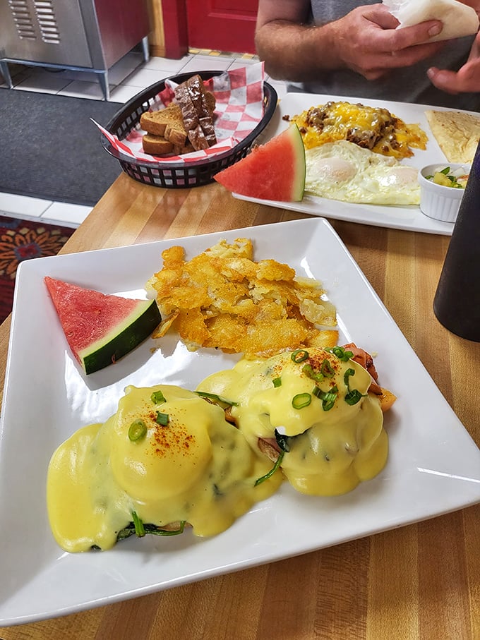 Eggs Benedict done right – golden hollandaise cascading over perfectly poached eggs with hash browns that achieve the ideal crisp-to-tender ratio.