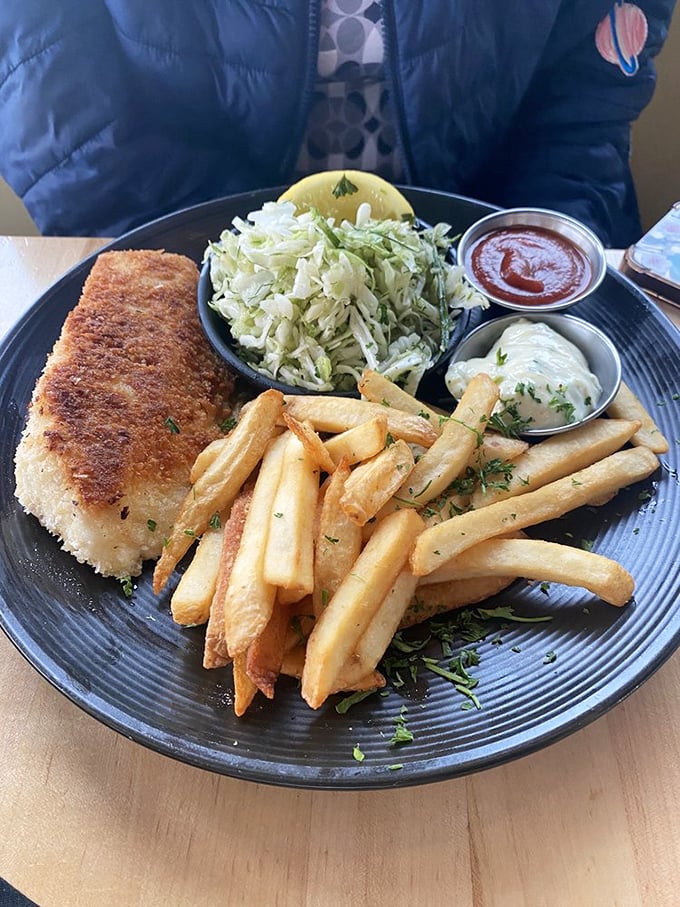 This isn't just fish and chips—it's a masterclass in texture. The golden-brown armor shatters to reveal pearly white fish that would make Neptune himself weep with joy.